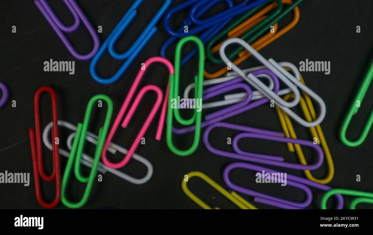 Colorful paper clips isolated on black background Stock Photo - Alamy