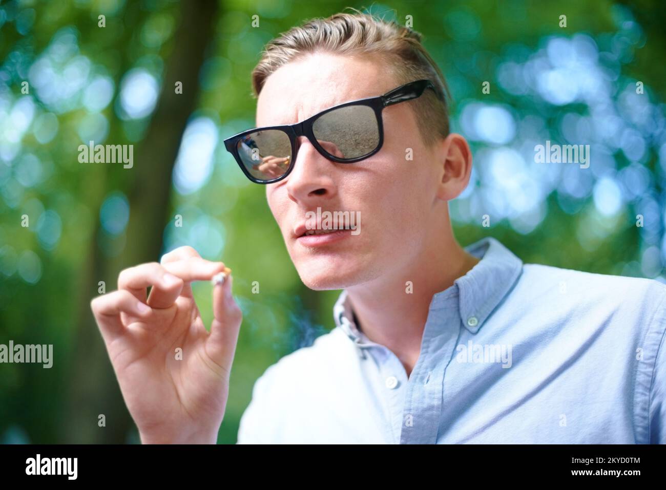 Takin a hit. a young man smoking a joint at an outdoor festival Stock ...