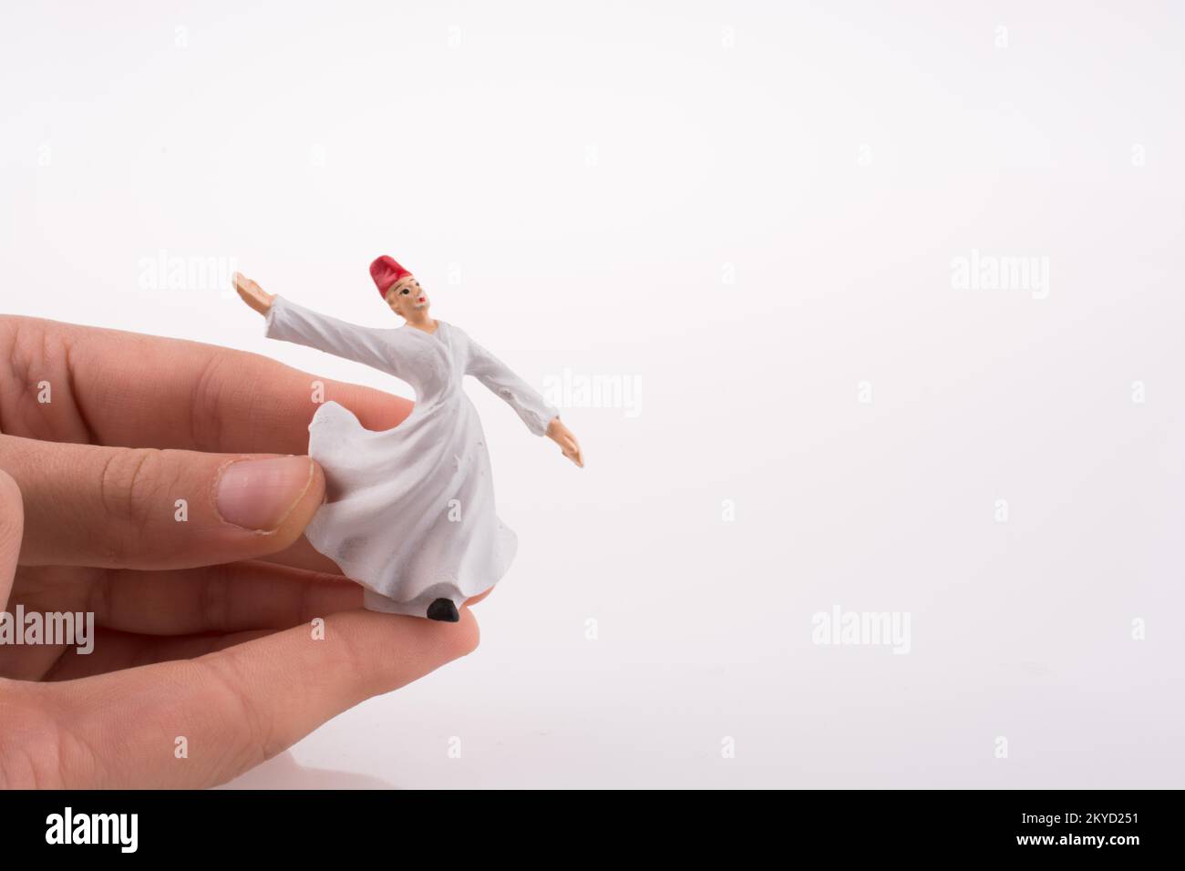 Hand holding a Sufi Dervis on a white background Stock Photo - Alamy