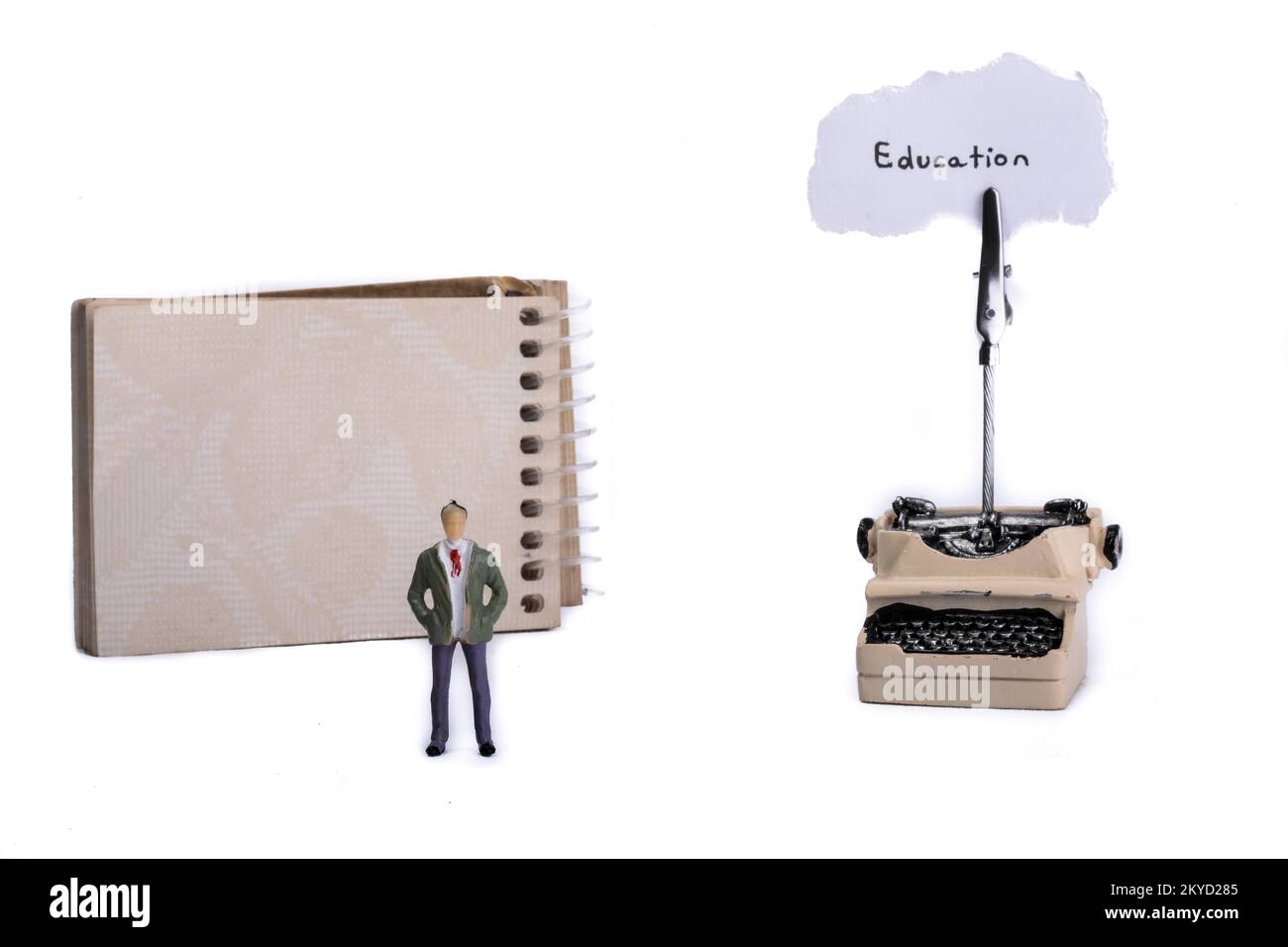 Man standing in front of a typewriter and a spiral notebook on a white ...