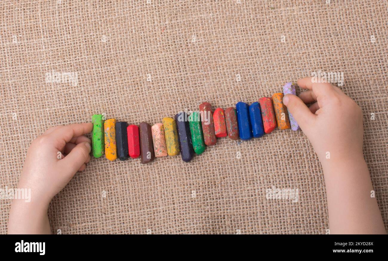 Toddlers hand putting crayons in line on canvas Stock Photo - Alamy