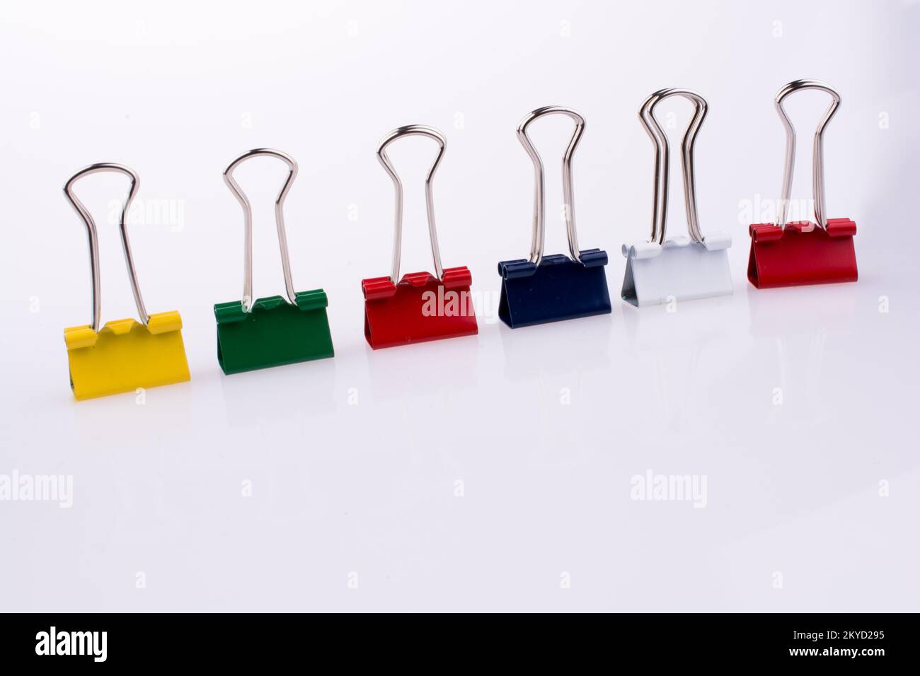 Colored paper clips on a white background Stock Photo - Alamy