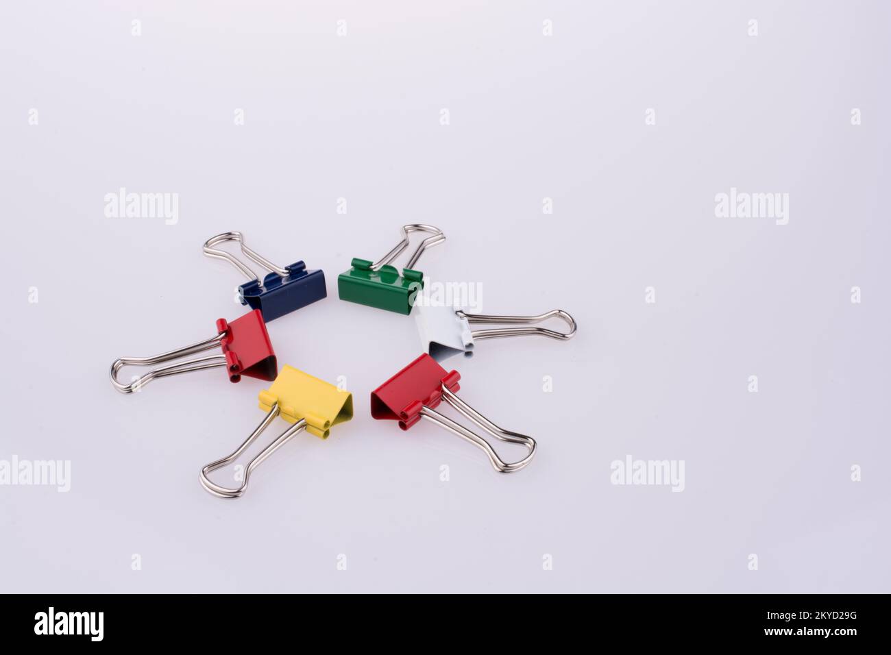 Colored paper clips on a white background Stock Photo - Alamy