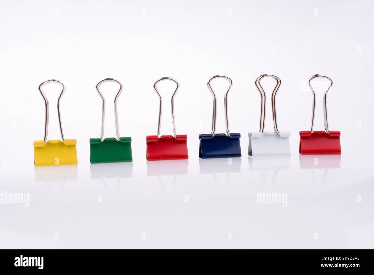 Colored paper clips on a white background Stock Photo - Alamy