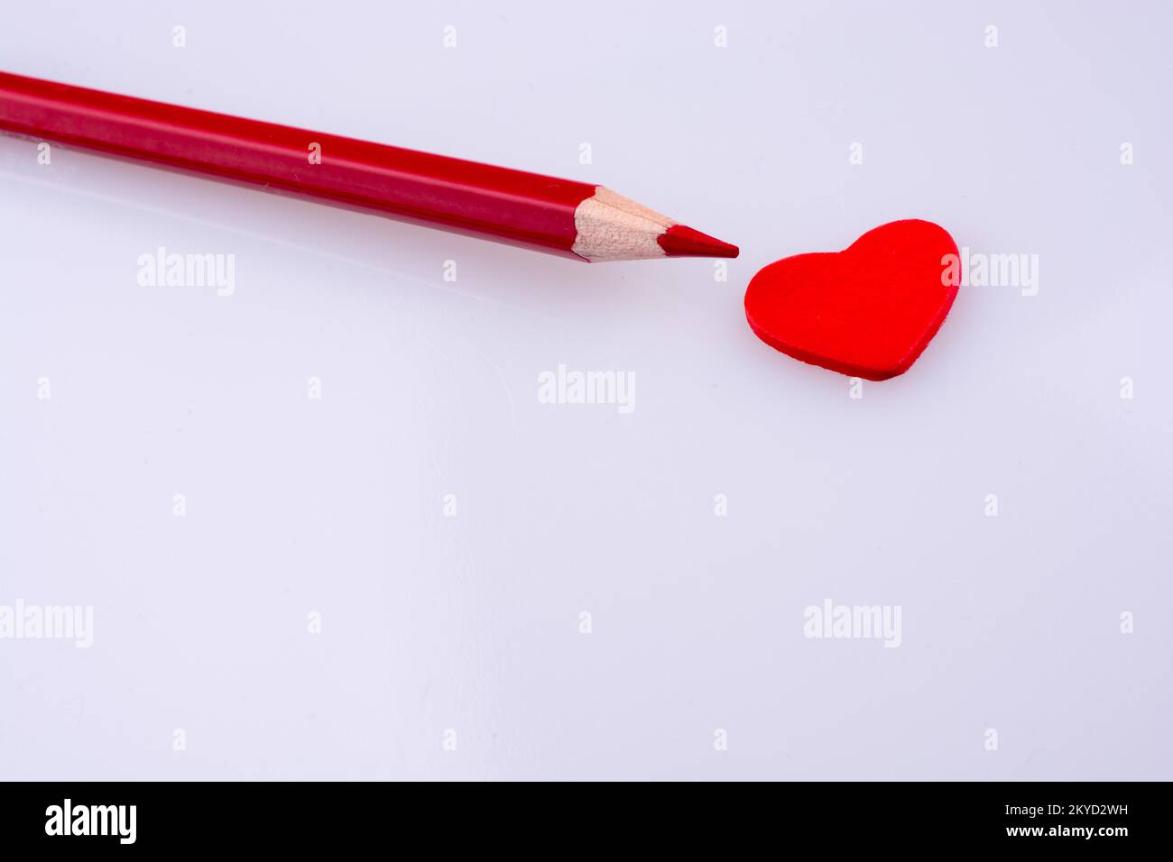 Pencil pointing a red heart Stock Photo - Alamy