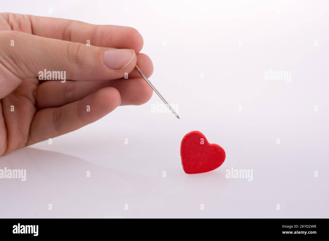 Hand pointing a needle on a heart Stock Photo - Alamy