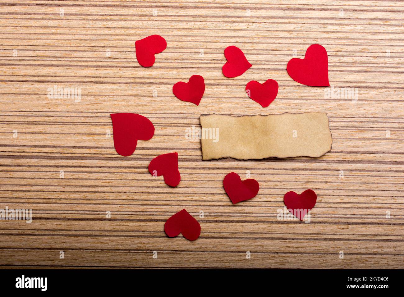 Red color paper hearts a yellow torn paper Stock Photo - Alamy