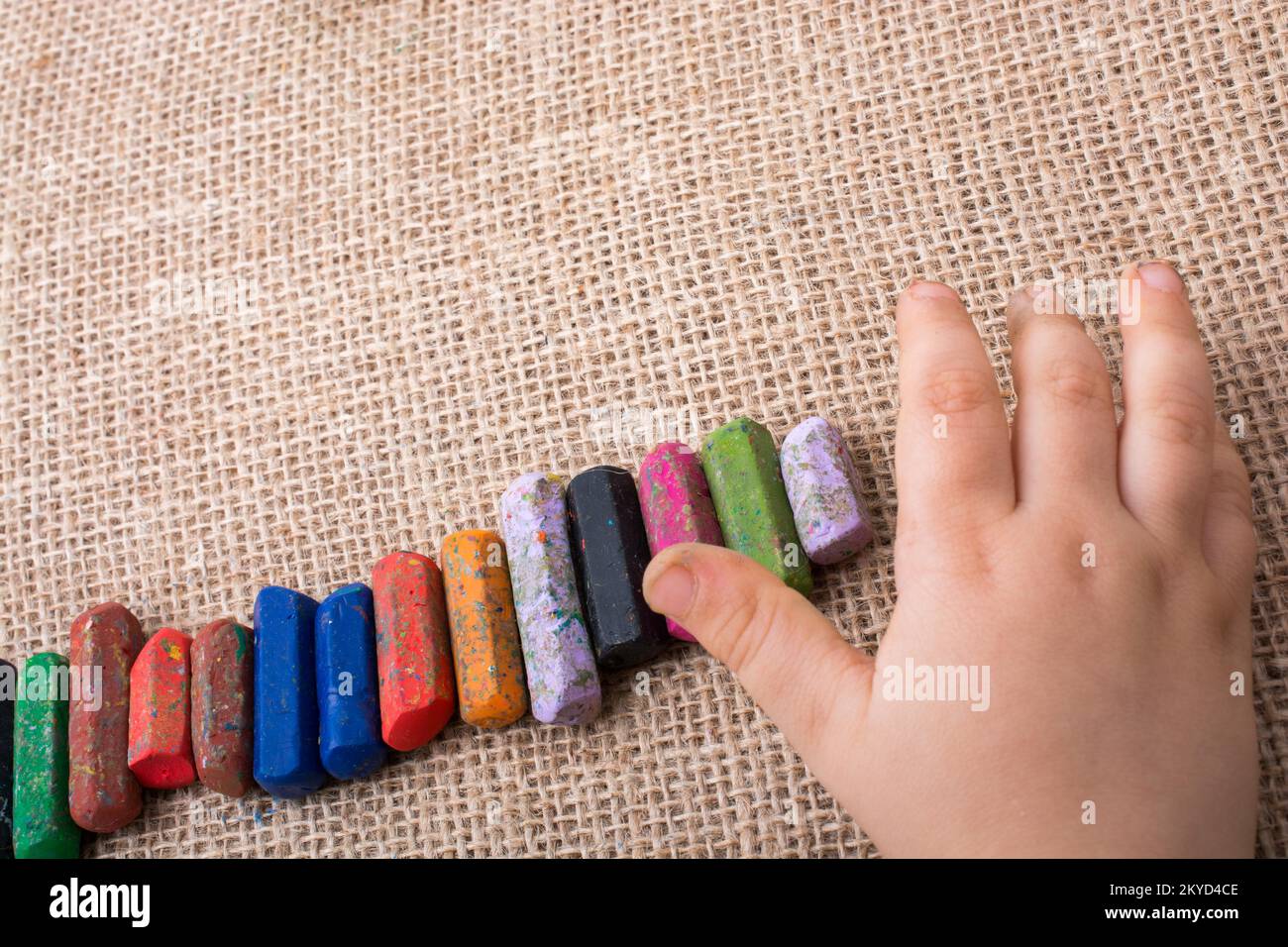 Toddlers hand putting crayons in line on canvas Stock Photo - Alamy