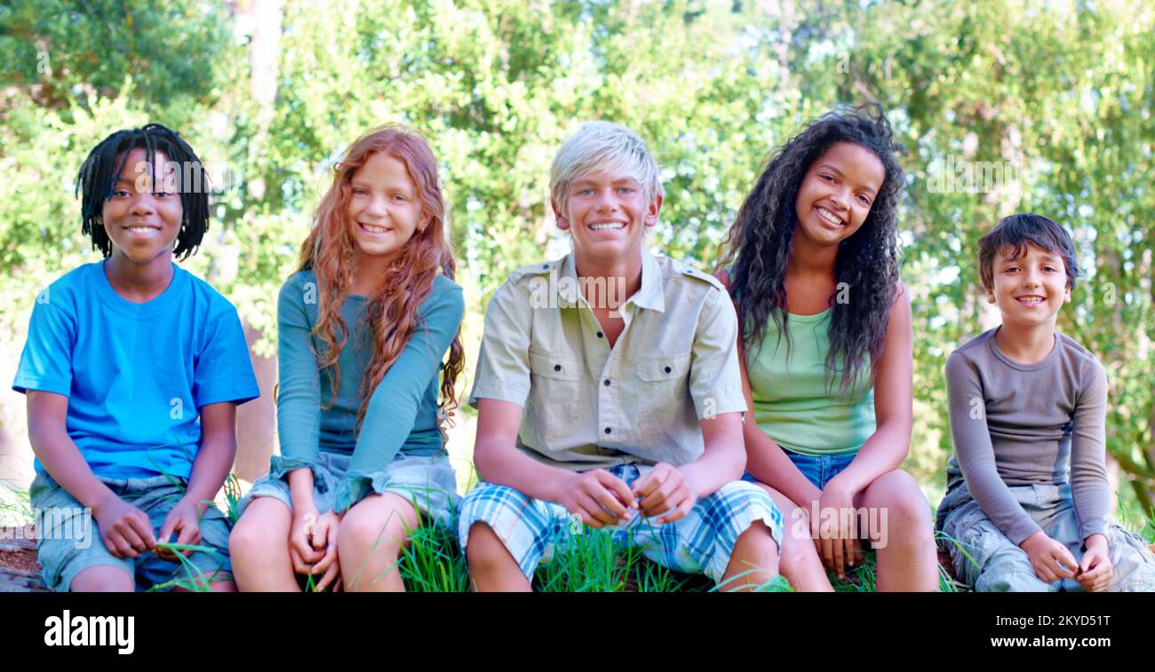 Next generation eco-warriors. A group of kids sitting outside smiling ...