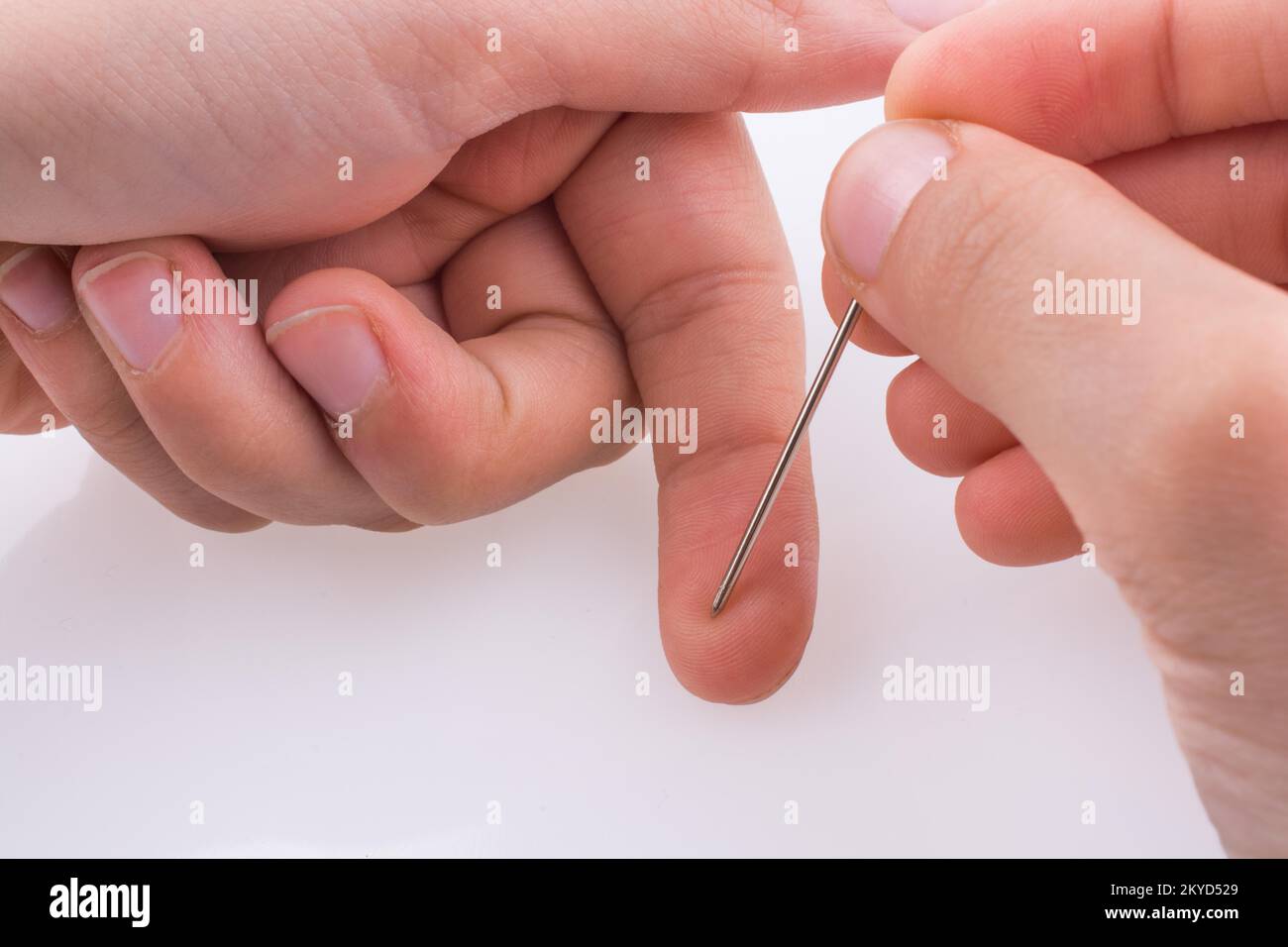 Hand holding a needle on a white background Stock Photo - Alamy