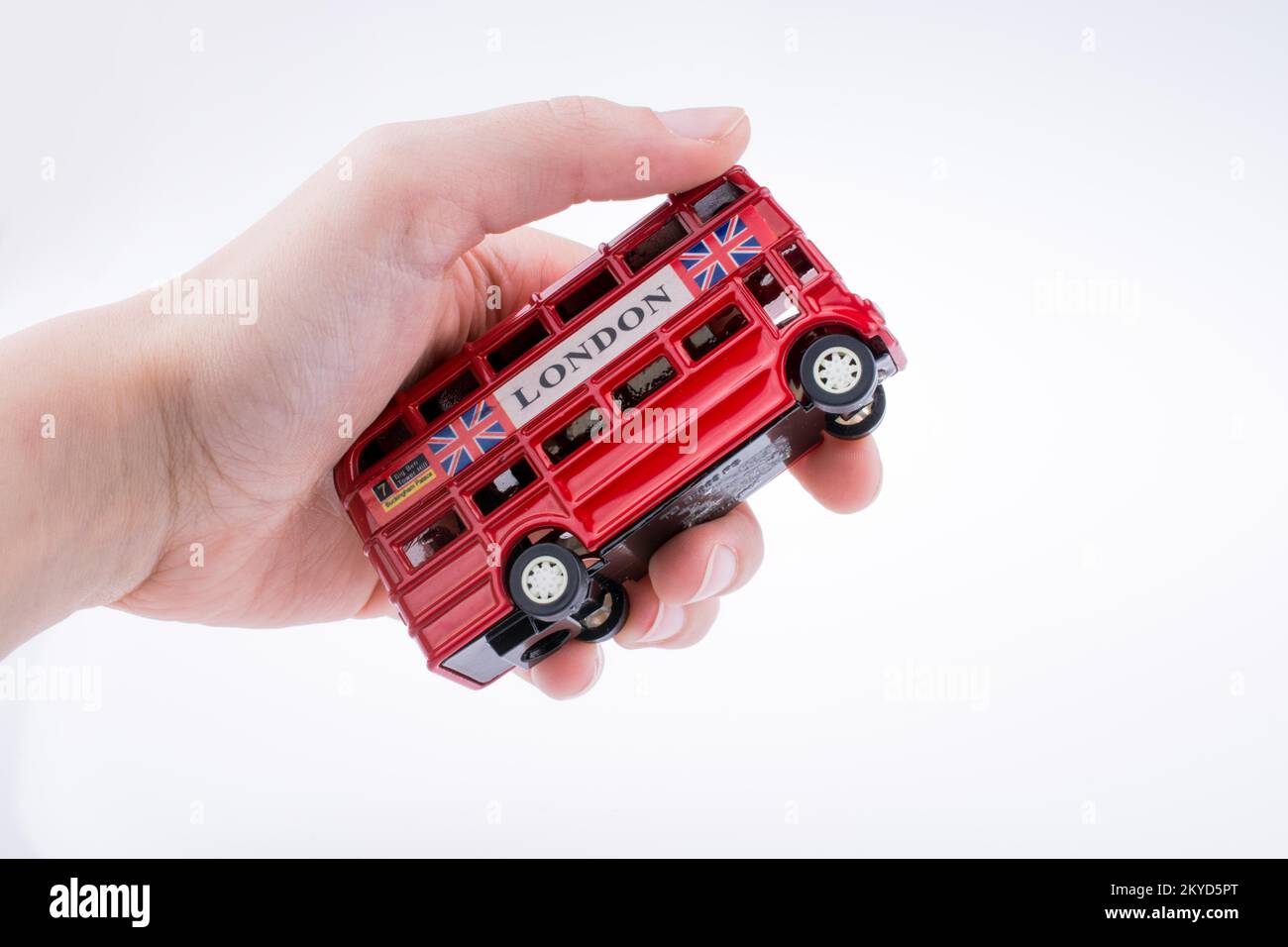 Hand holding a London Bus on a white background Stock Photo - Alamy