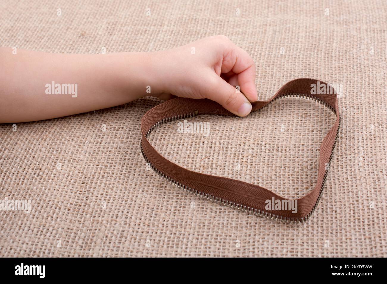 Heart shaped object in hand on a canvas background Stock Photo - Alamy