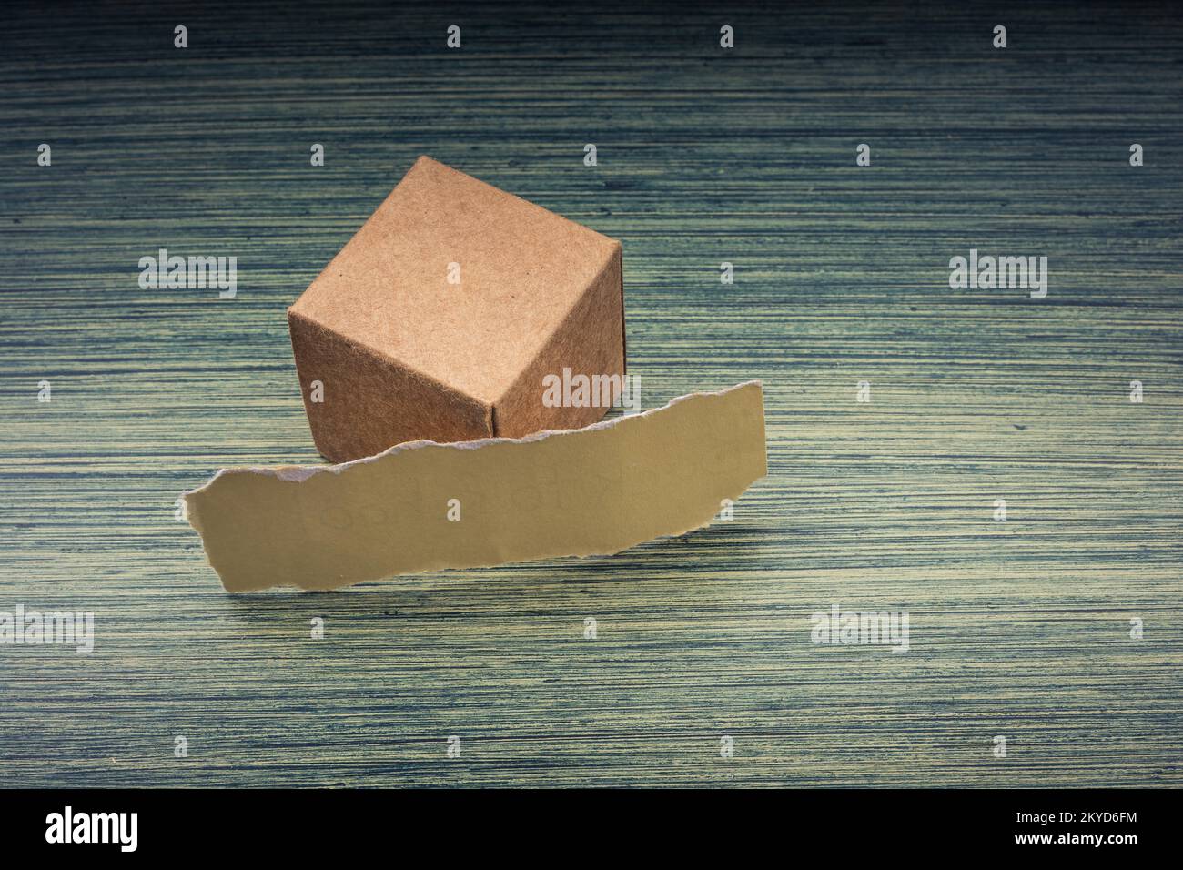 Torn paper and a paper box cube on wooden texture Stock Photo - Alamy