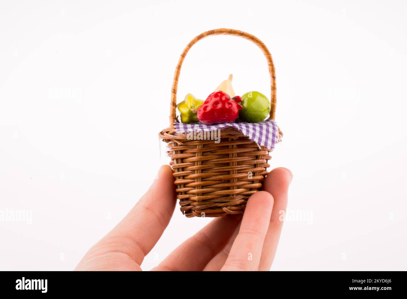Hand holding a fruit basket on a white background Stock Photo - Alamy