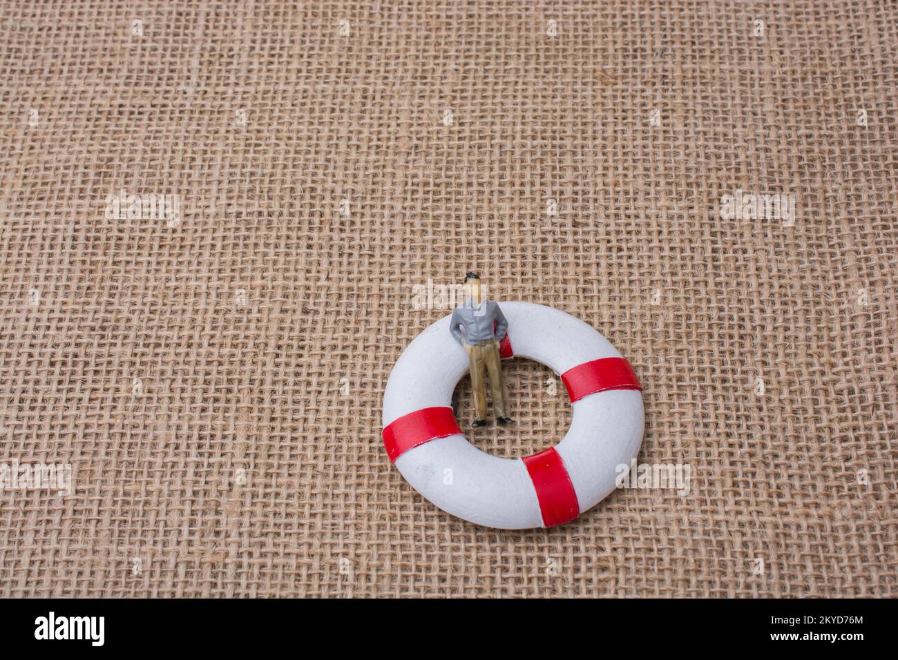 Little figurine man in a life preserver on life on canvas Stock Photo ...
