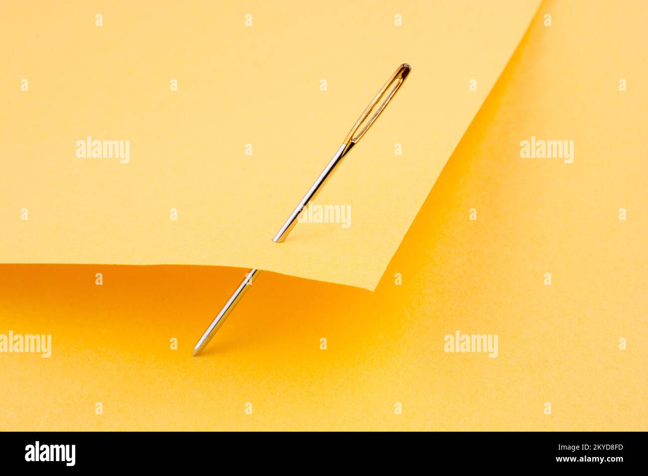 Needle pierced yellow color note paper Stock Photo - Alamy