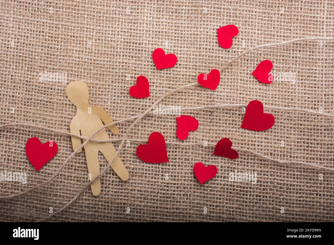 Paper man and heart icons on linen threads on canvas Stock Photo - Alamy