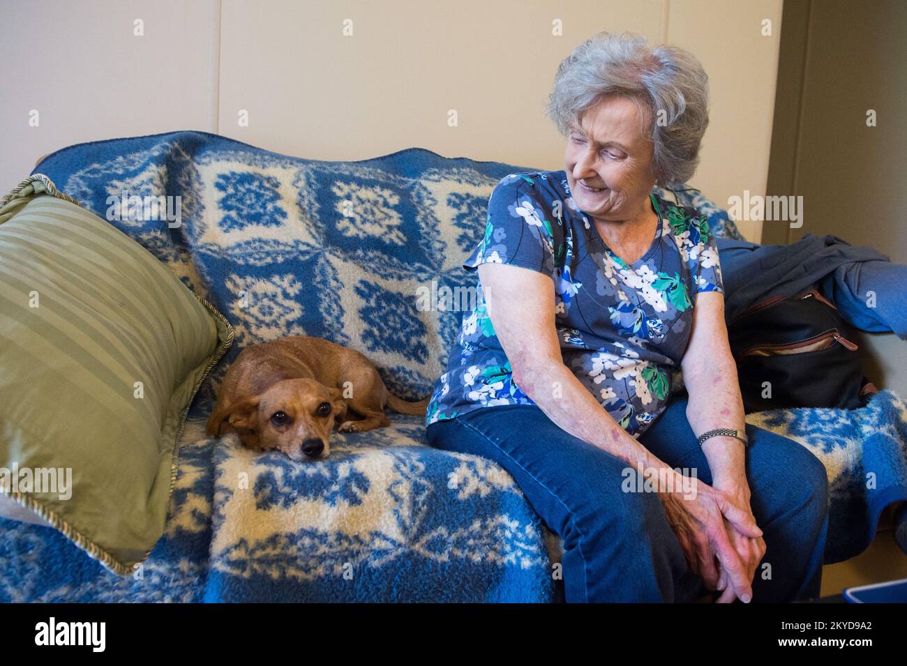 Flood survivor Mary Ann Wallace and her dog, Chi Chi, sit on a couch ...
