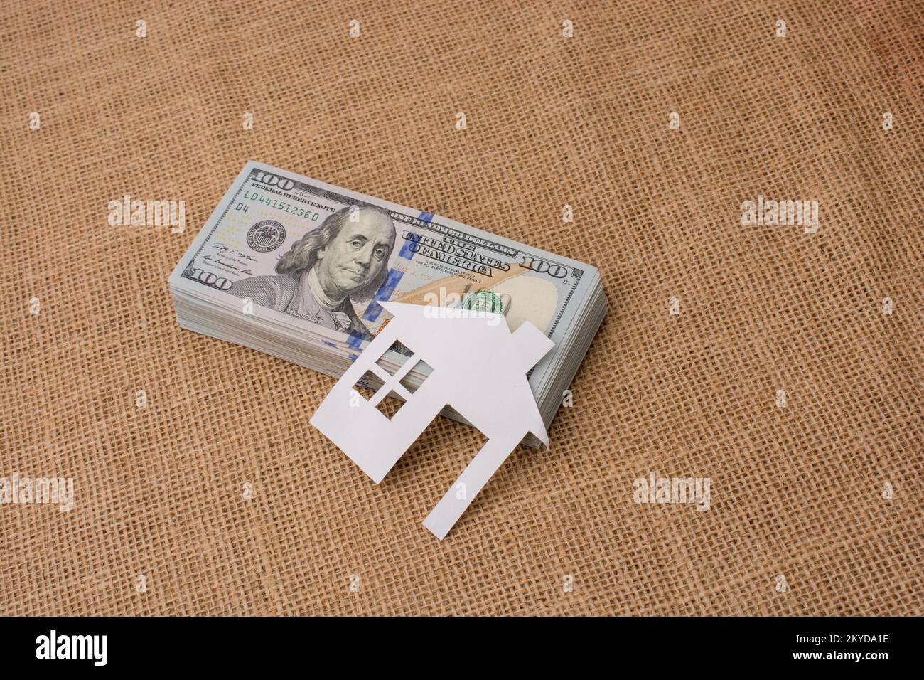 Paper house placed beside a bundle of US dollar banknote Stock Photo ...