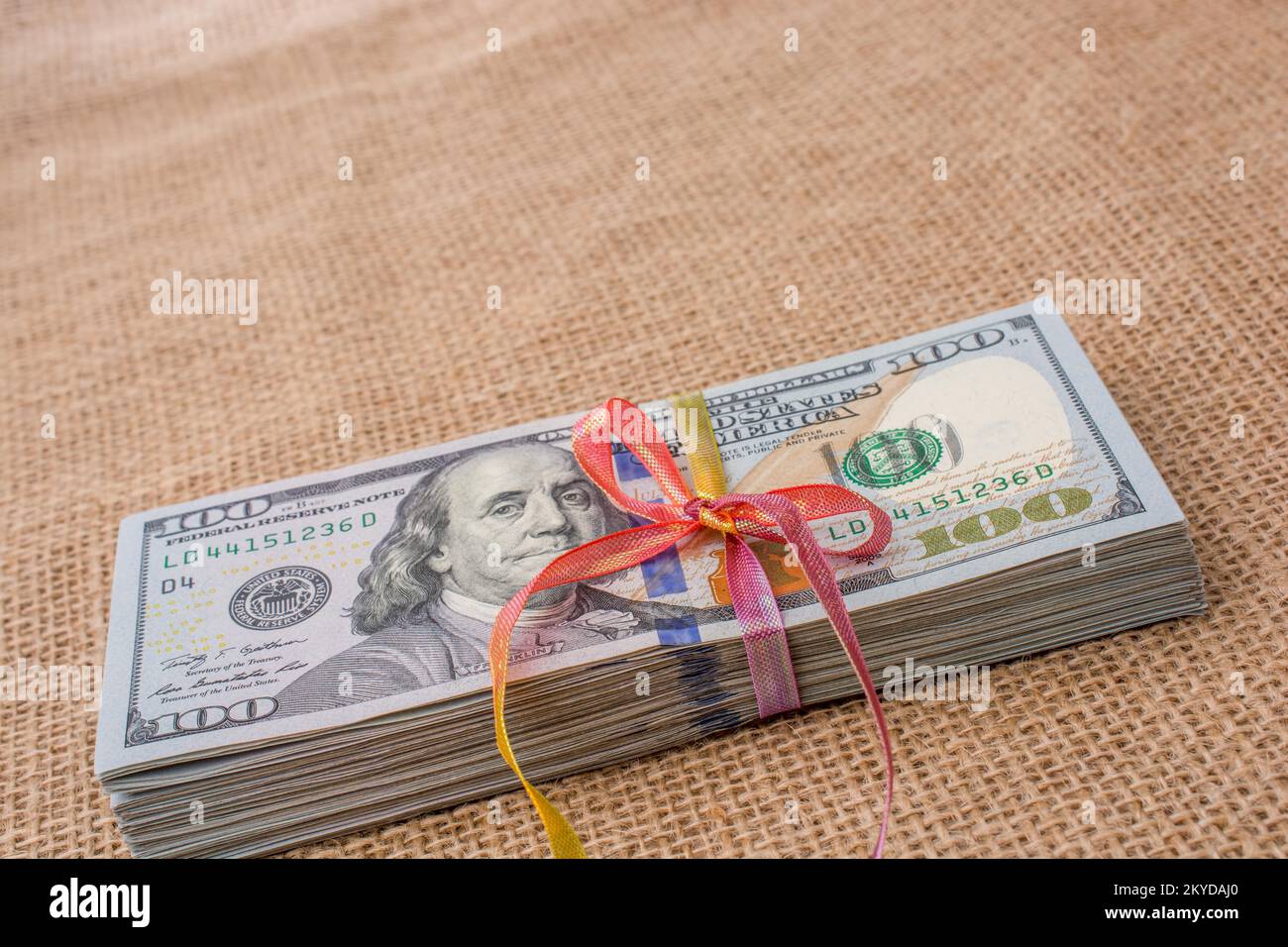 Banknote bundle of US dollar tied with colorful a ribbon Stock Photo ...