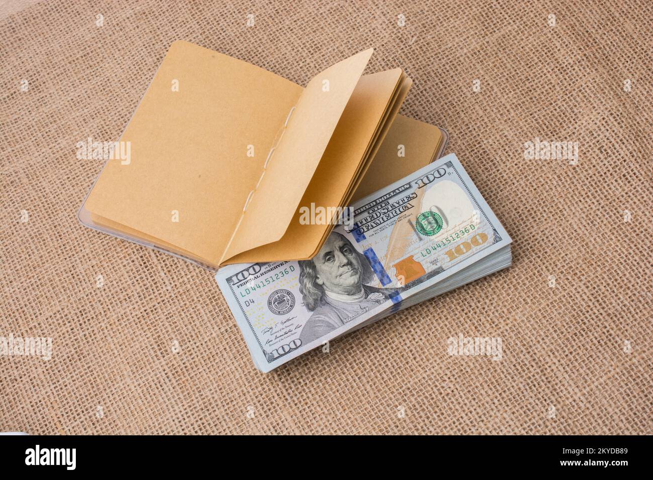 Notebook placed beside bundle of US dollar banknotes Stock Photo - Alamy