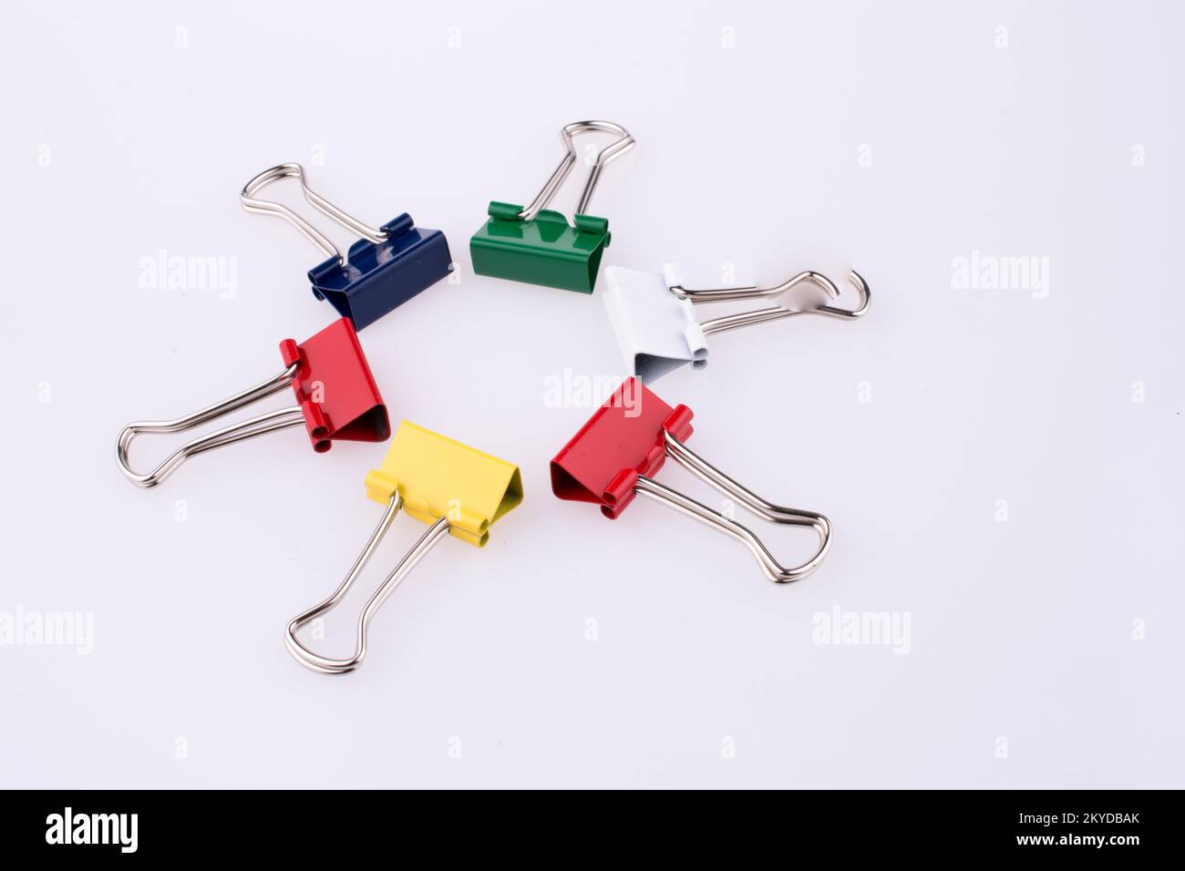 Colored paper clips on a white background Stock Photo - Alamy