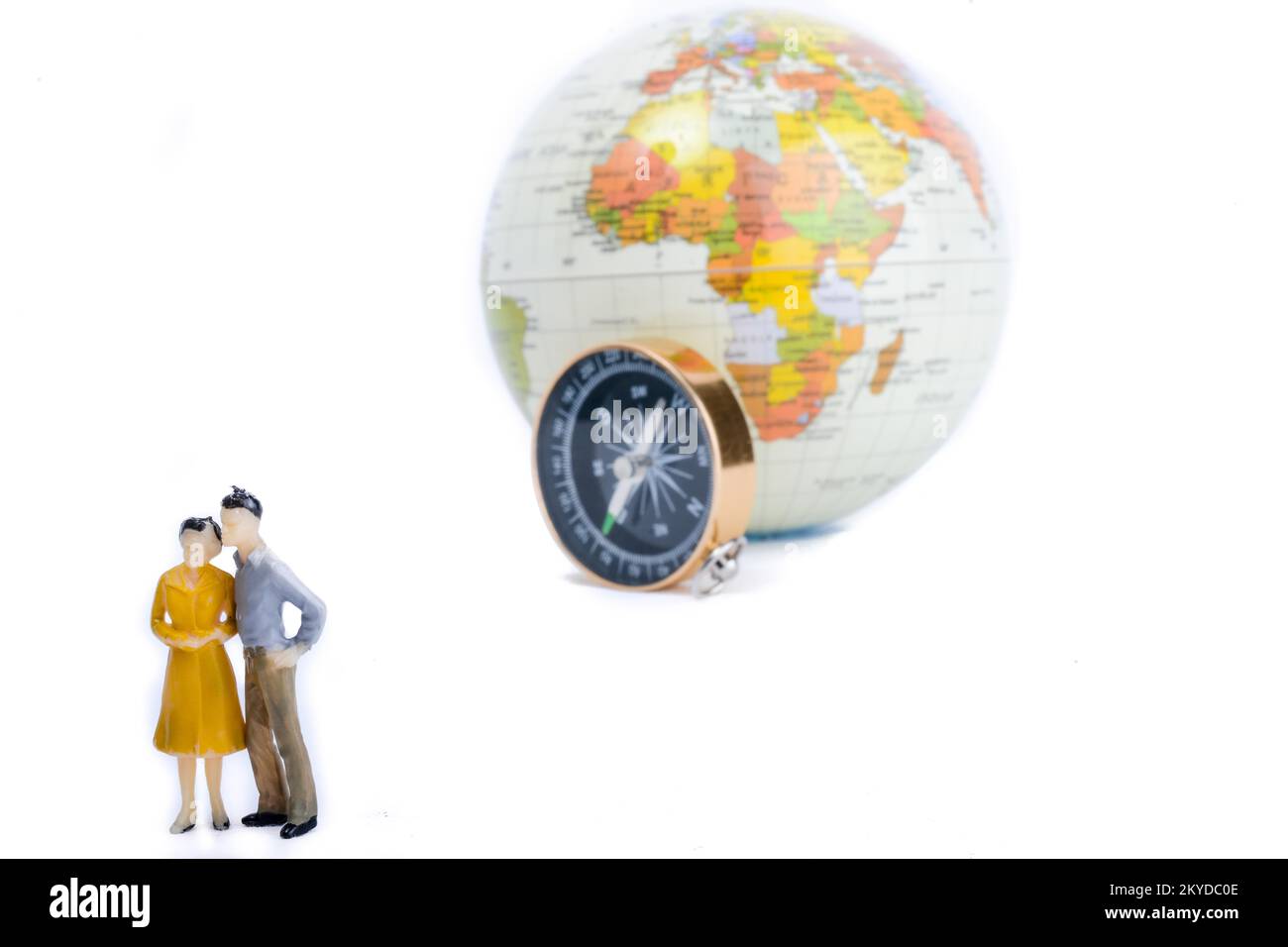 A couple by the side of a globe with a compass on isolated white ...