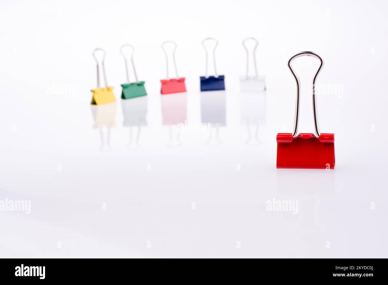 Colored paper clips on a white background Stock Photo - Alamy