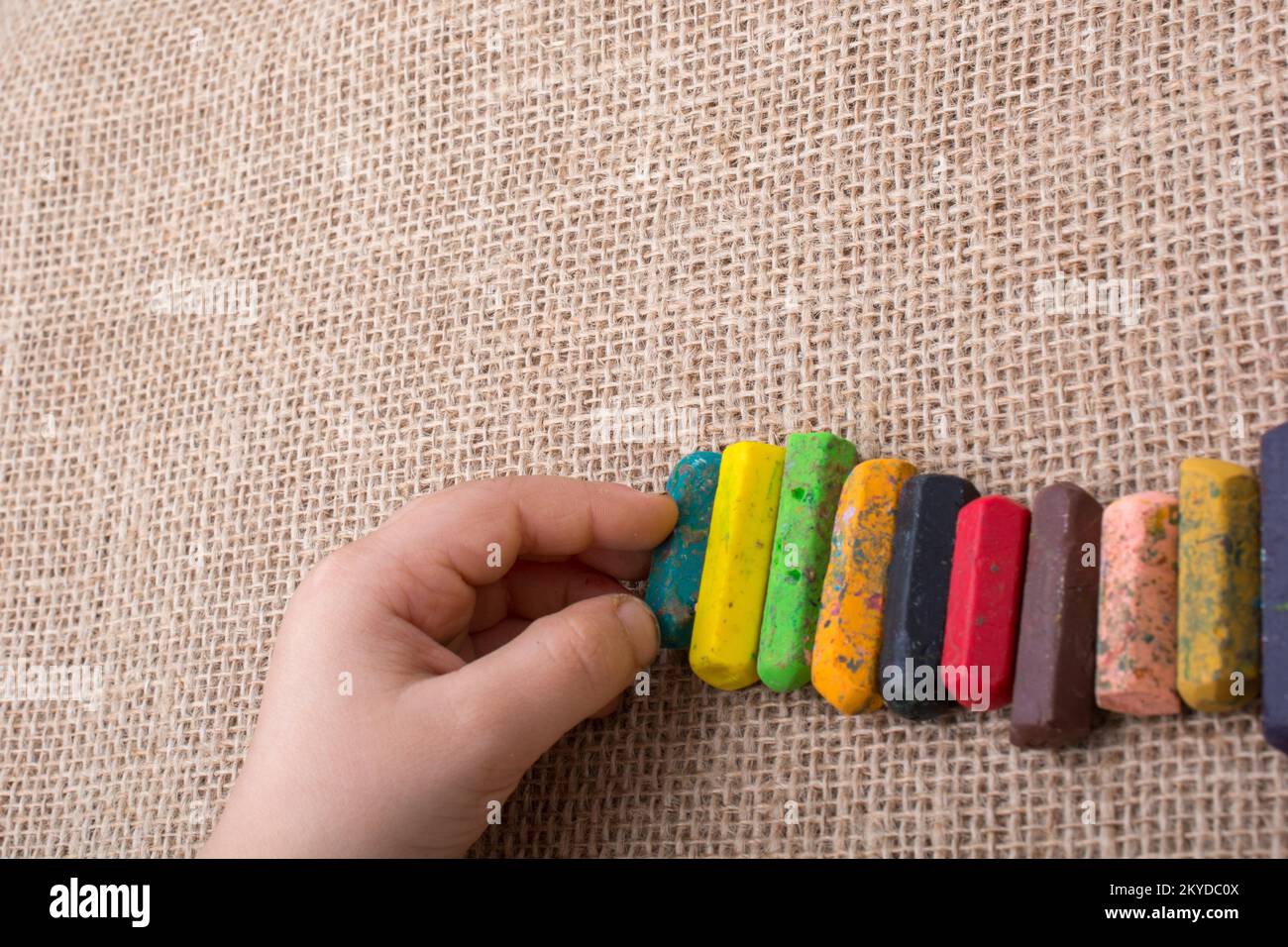 Toddlers hand putting crayons in line on canvas Stock Photo - Alamy