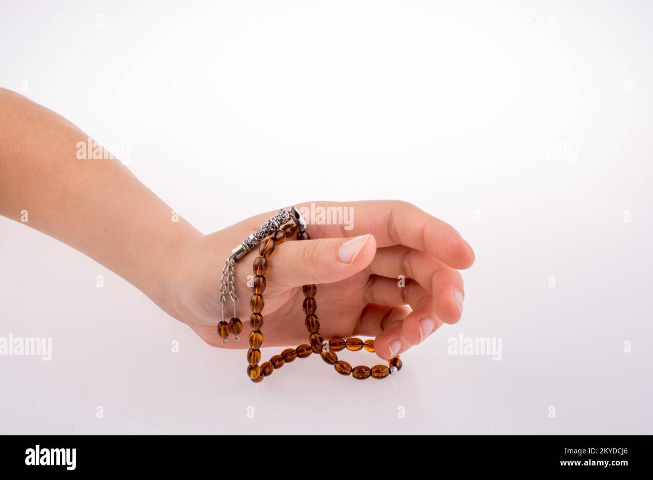 Hand holding a tespih on a white background Stock Photo - Alamy