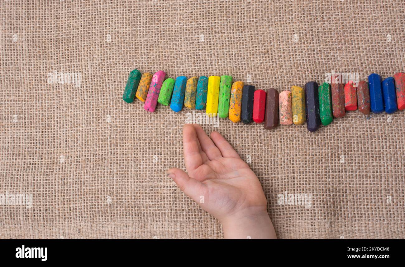 Toddlers hand putting crayons in line on canvas Stock Photo - Alamy