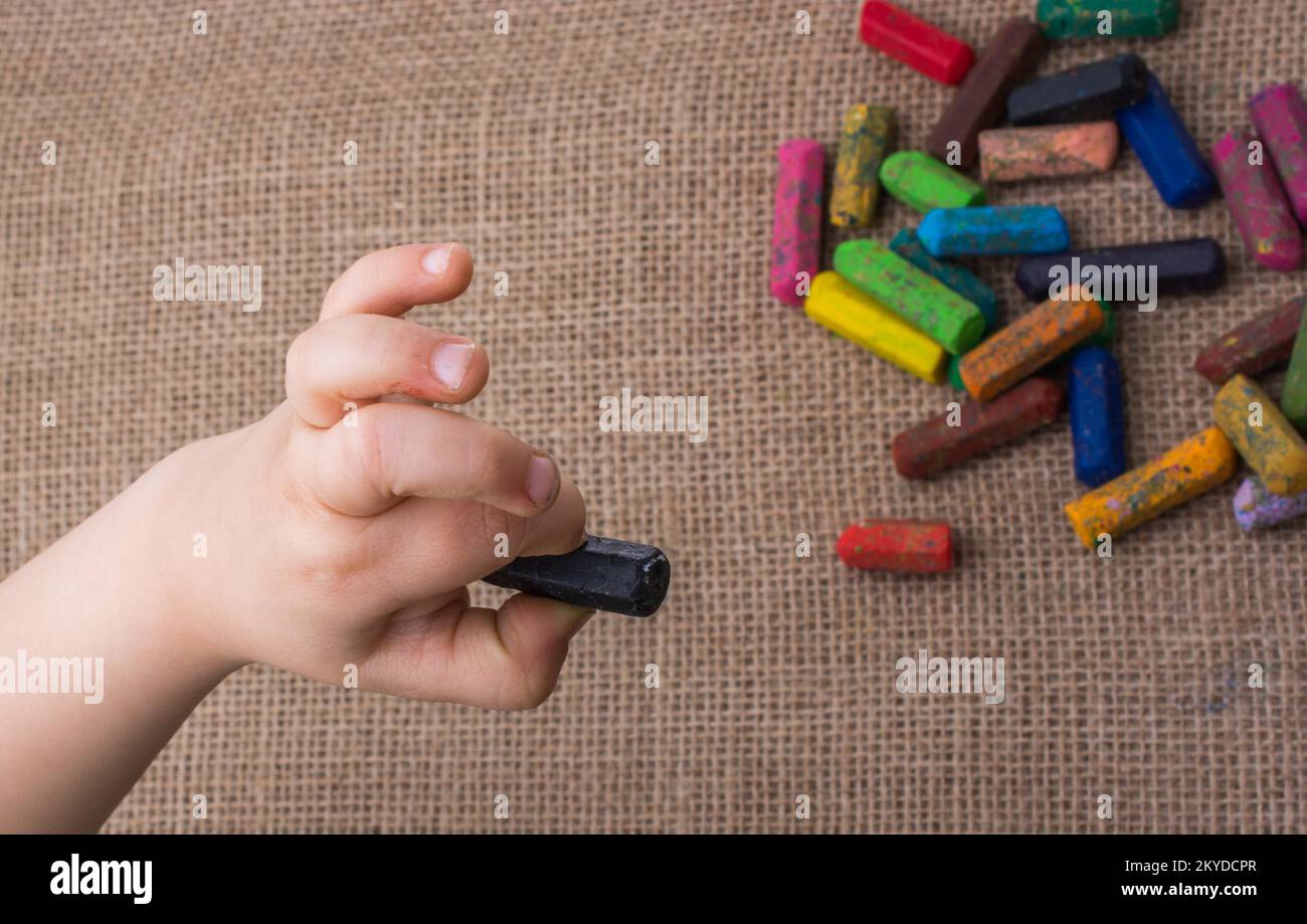 Used color crayons and a toddlers hand holding one Stock Photo - Alamy