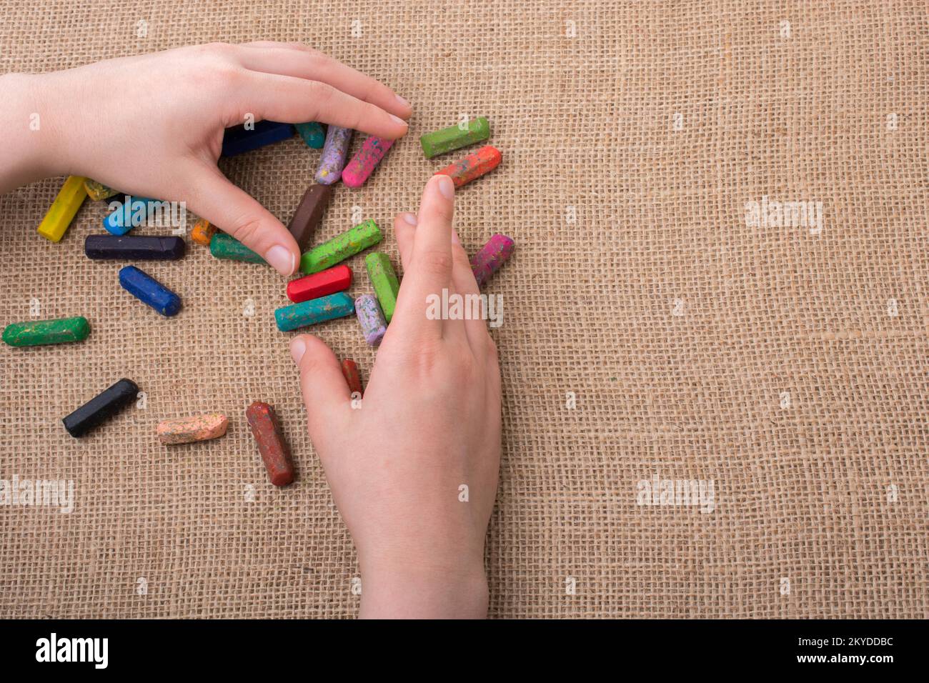 Used color crayons and a hand holding some Stock Photo - Alamy