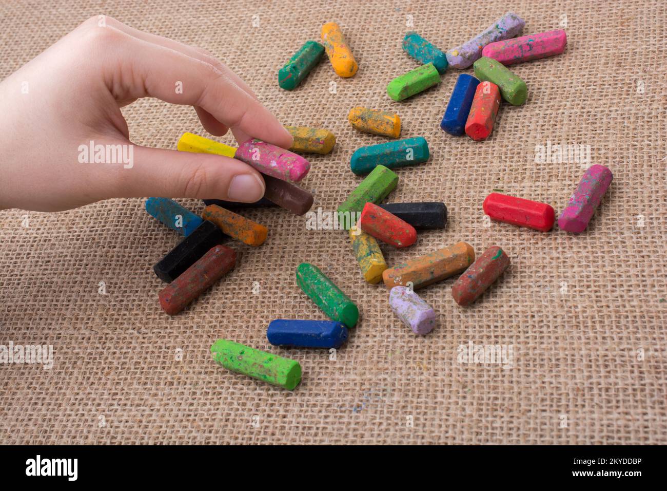 Used color crayons and a hand holding one Stock Photo - Alamy