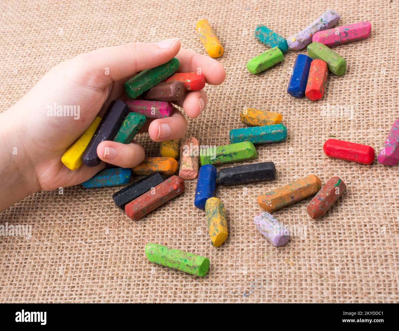 Used color crayons and a hand holding some Stock Photo - Alamy