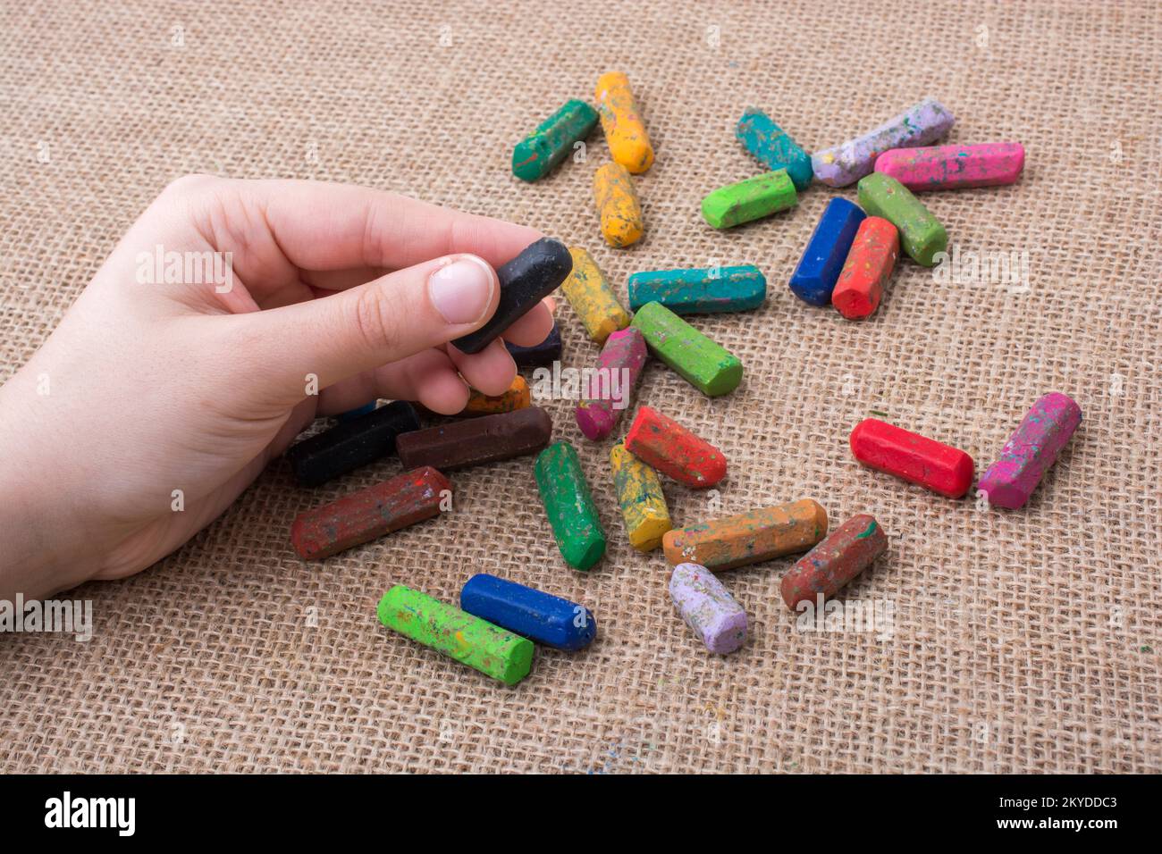 Used color crayons and a hand holding one Stock Photo - Alamy