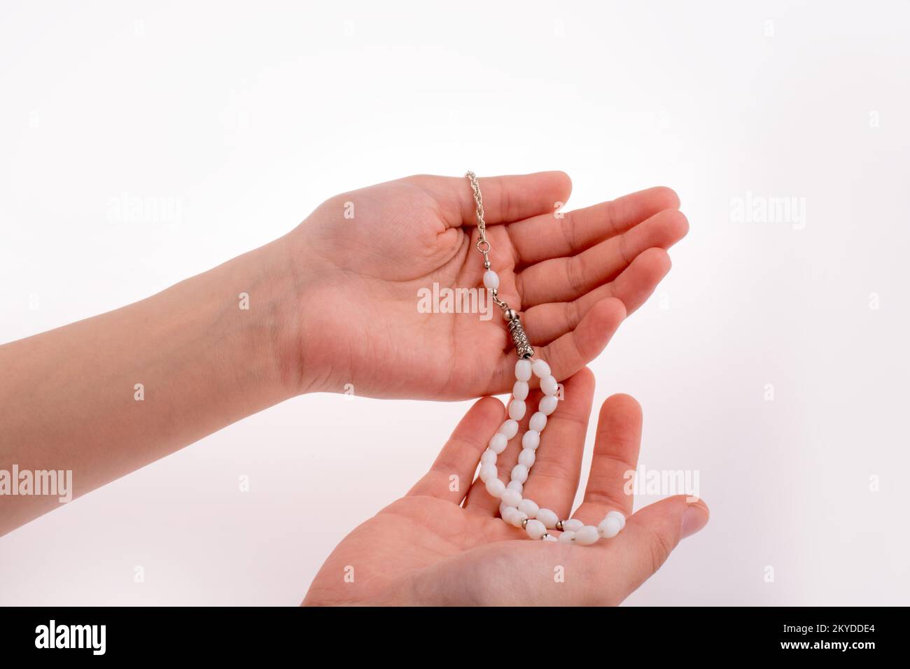Hand holding a tespih on a white background Stock Photo - Alamy