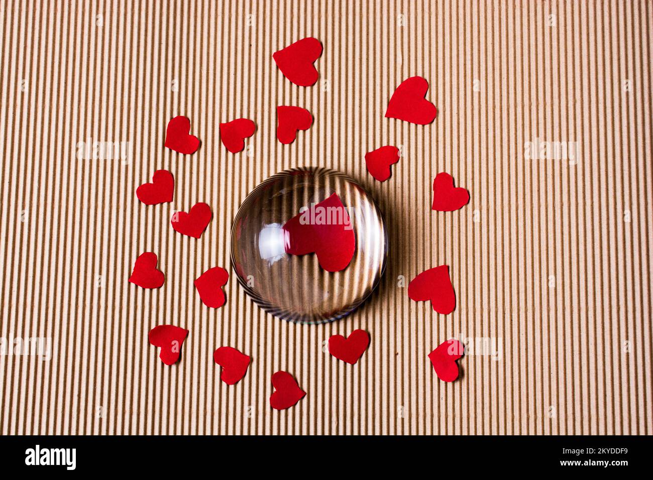 Red color paper hearts under and around half glass globe Stock Photo ...