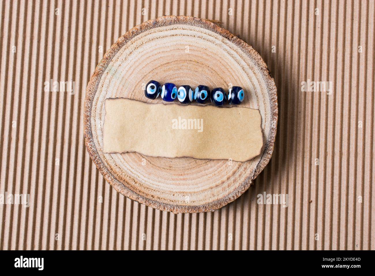 Evil eye beads and piece of burnt paper on wood log Stock Photo - Alamy