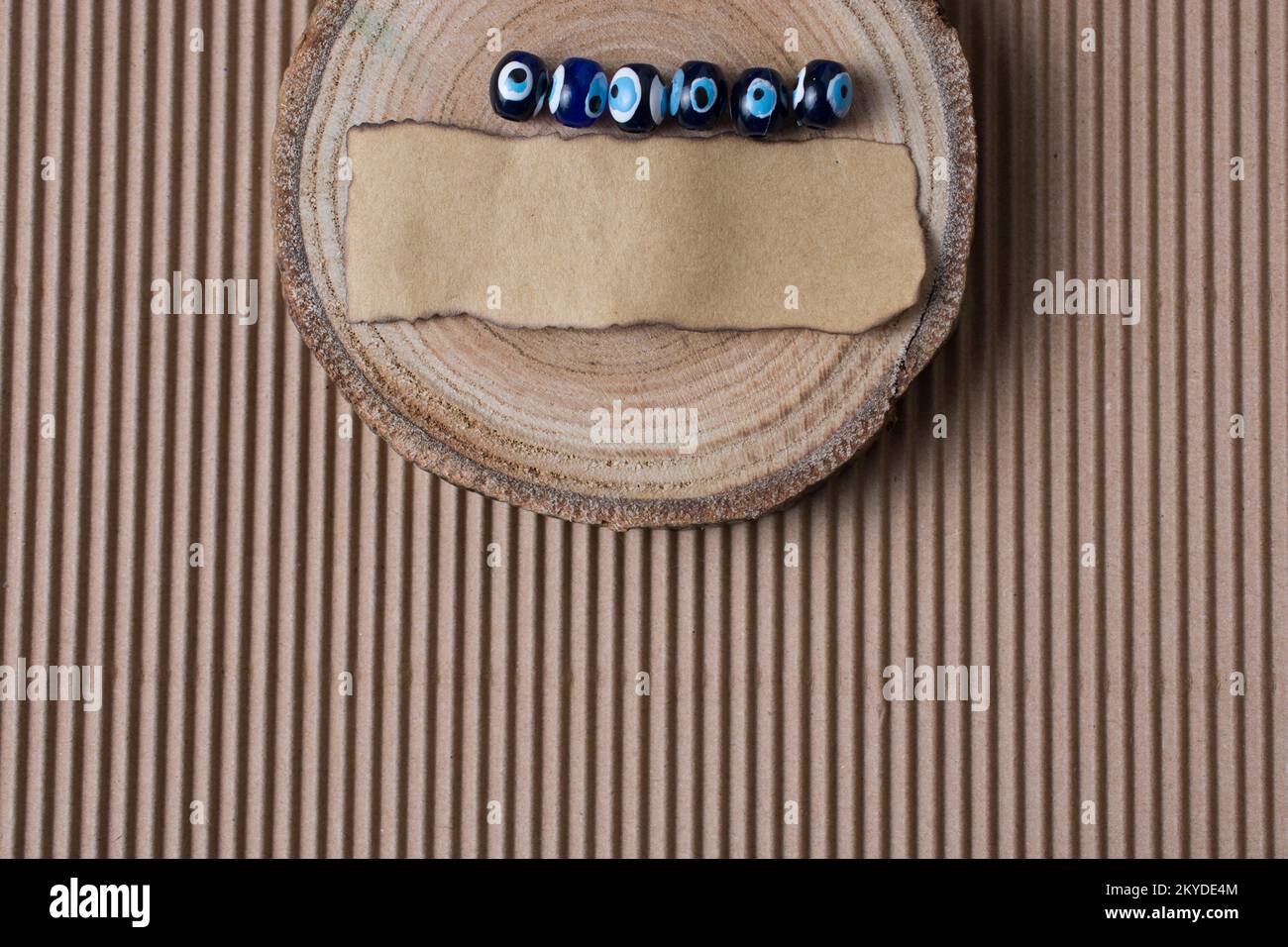 Evil eye beads and piece of burnt paper on wood log Stock Photo - Alamy