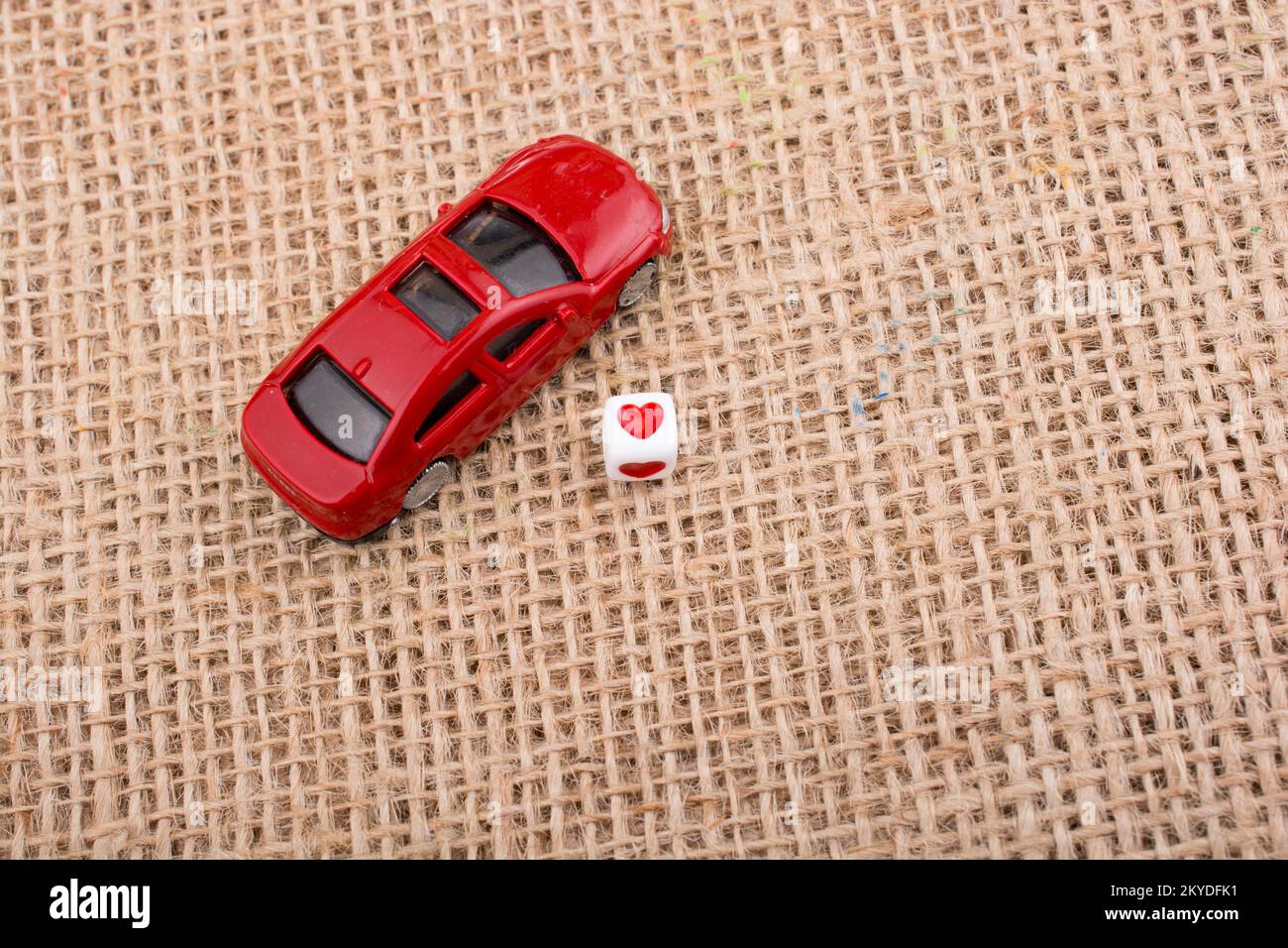 Love cube on a red toy car on a linen canvas Stock Photo - Alamy