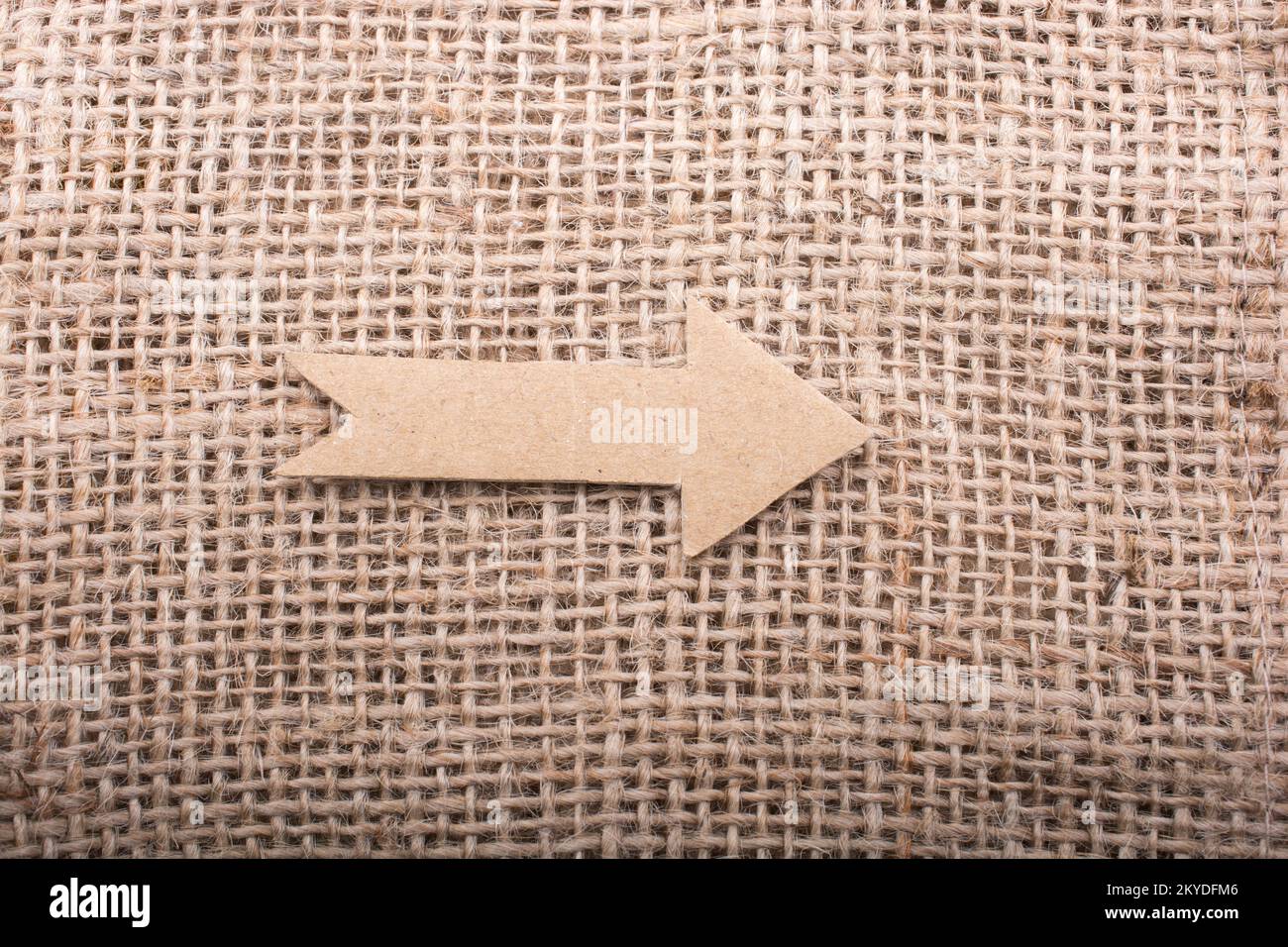 Arrow sign cut out of brown paper on canvas Stock Photo - Alamy