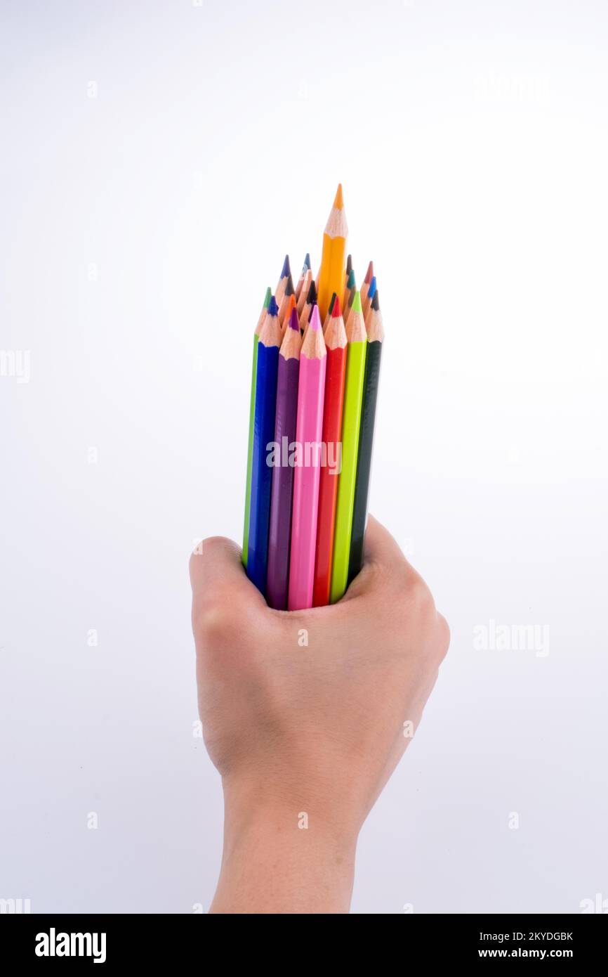 Hand holding color pencils on a white background Stock Photo - Alamy