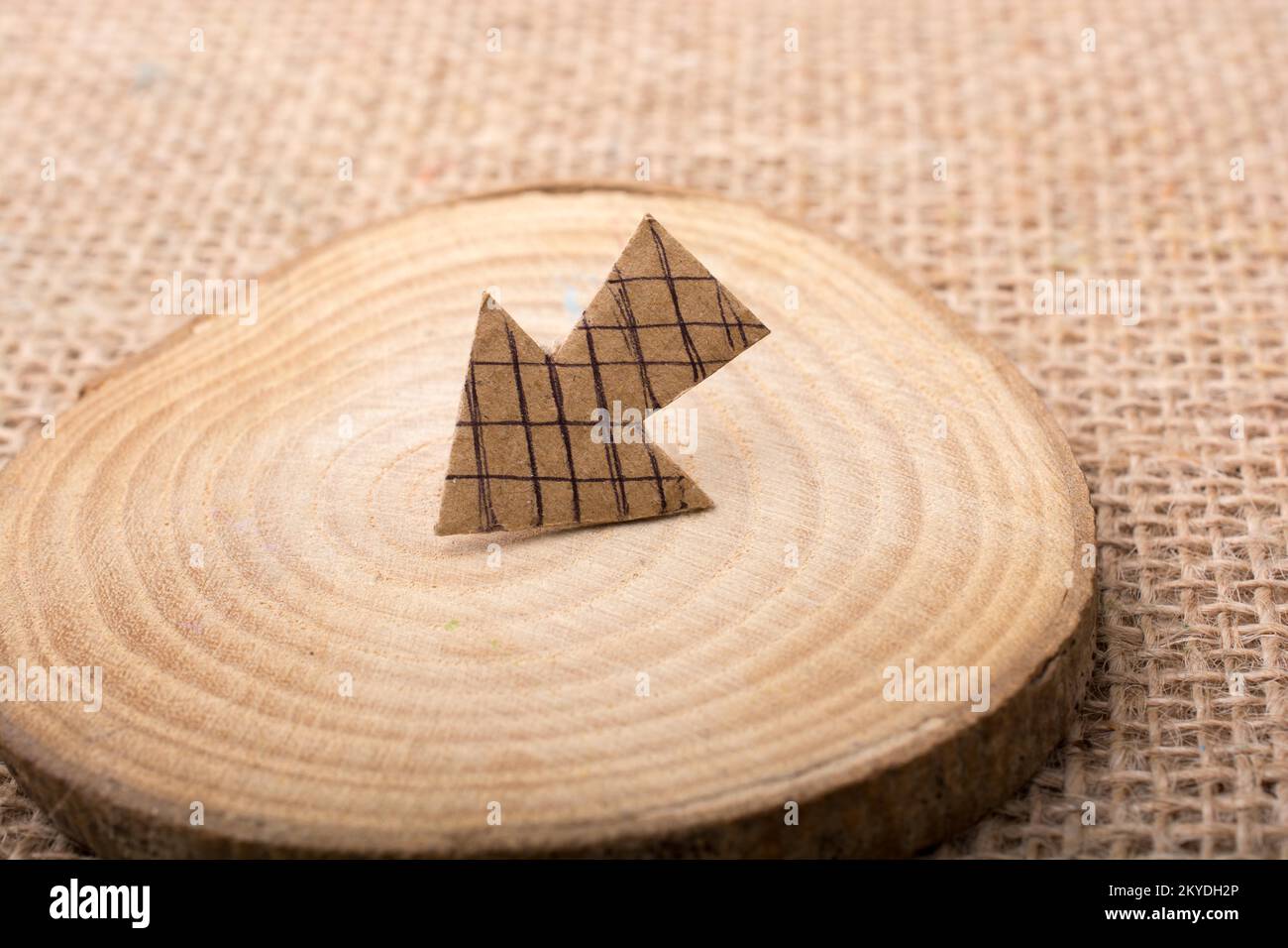 Arrow sign cut out of brown paper on piece of wood Stock Photo - Alamy