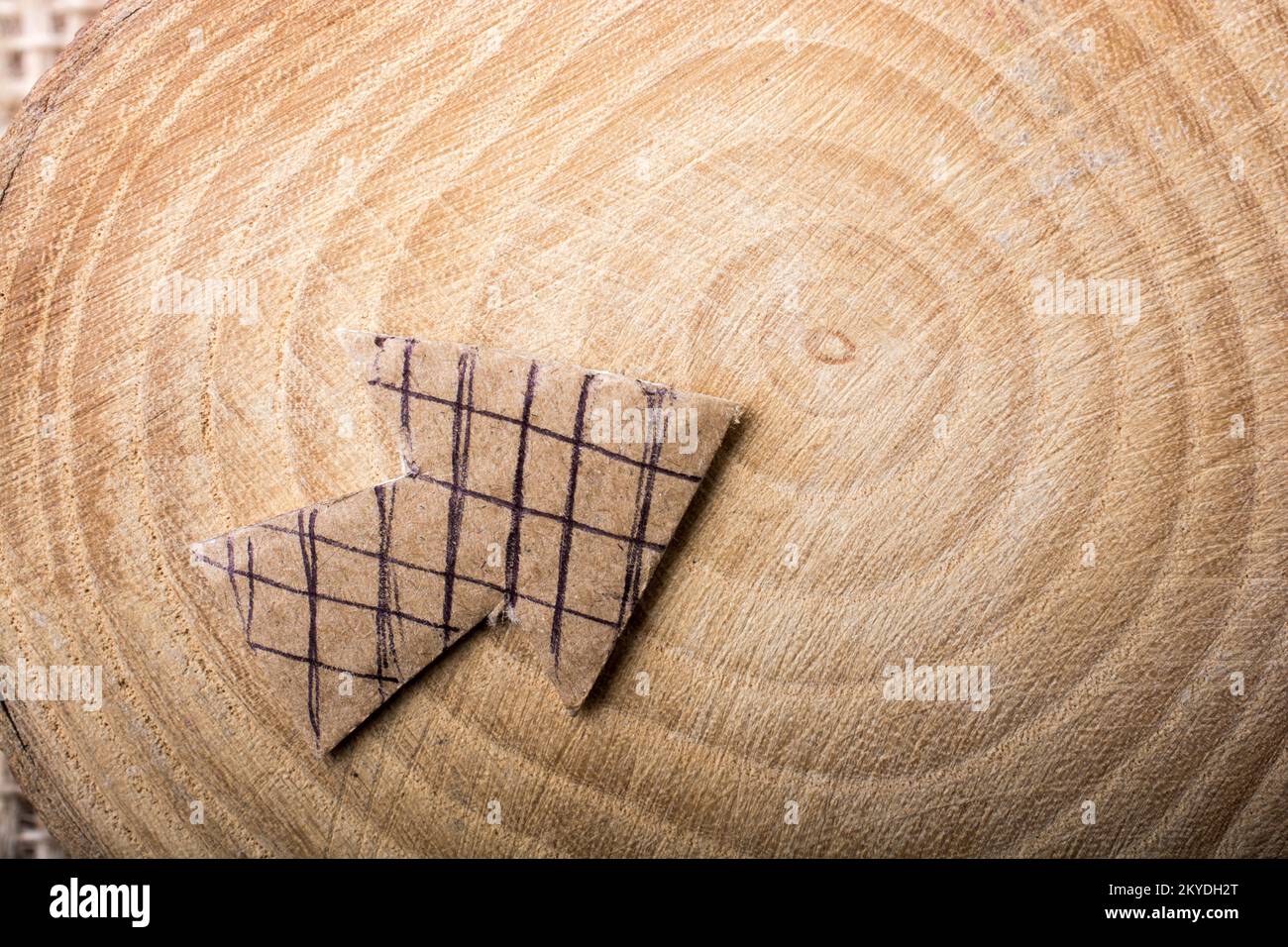 Arrow sign cut out of brown paper on piece of wood Stock Photo - Alamy