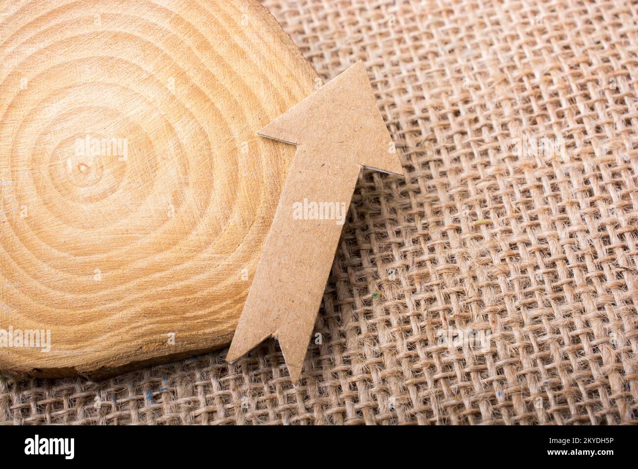 Arrow sign cut out of brown paper on piece of wood Stock Photo - Alamy