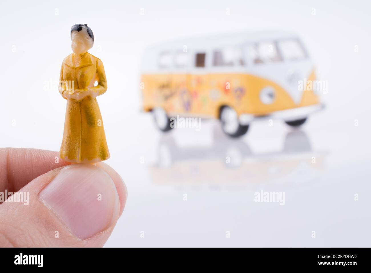 Hand holding a human figure near a peace van on a white background ...