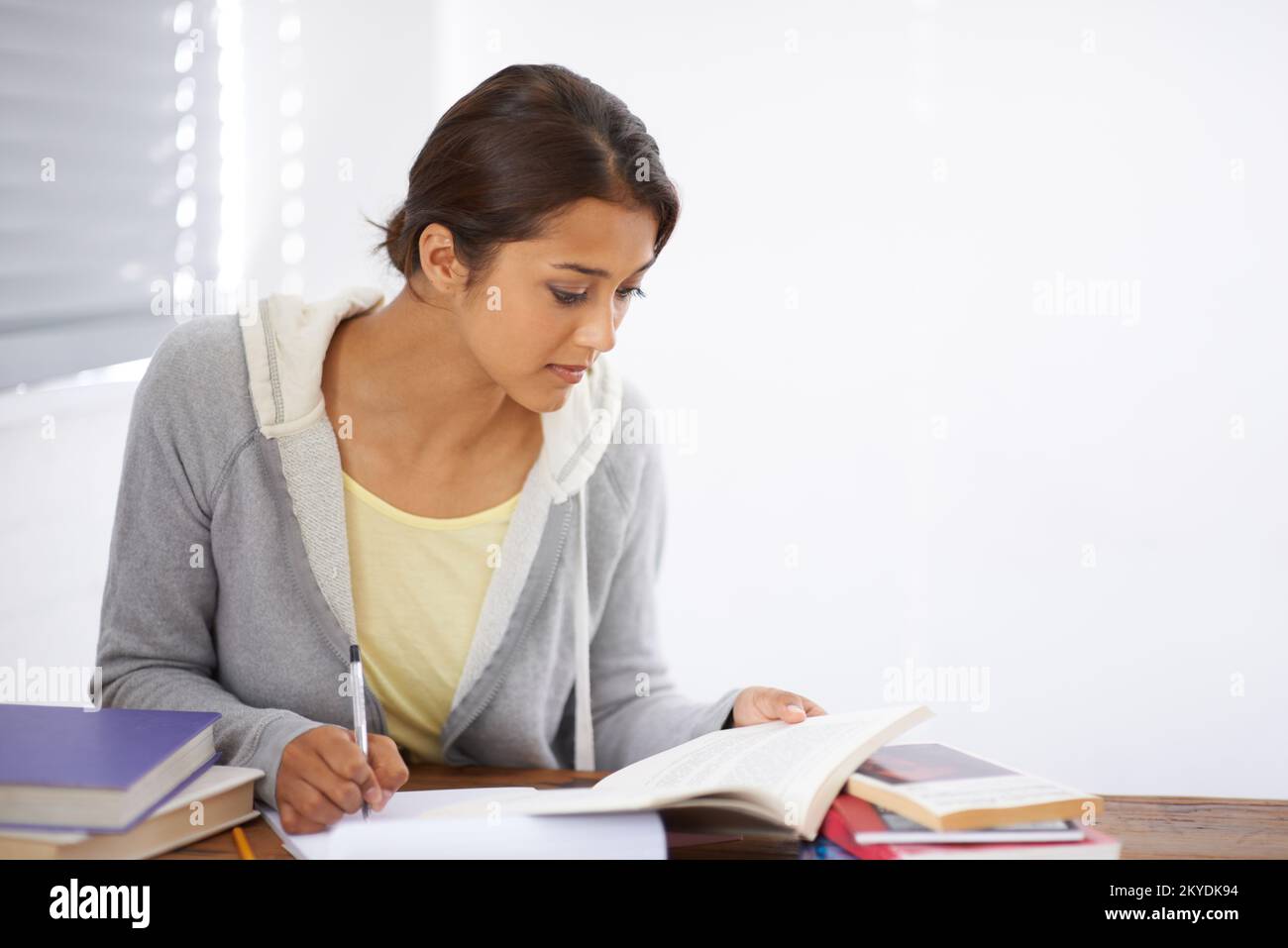 Highlighting the key points. A pretty college student taking notes from ...