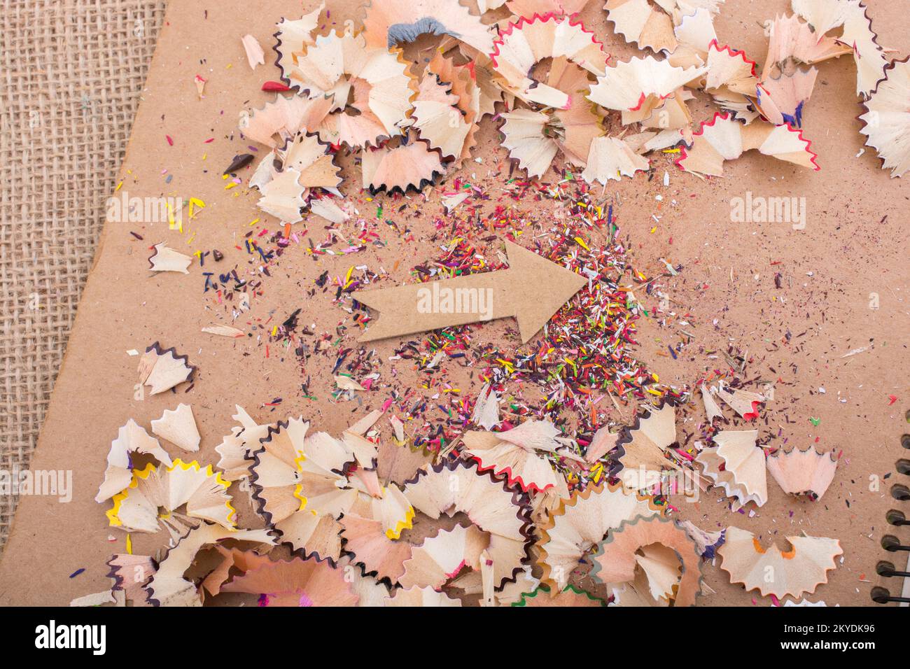 Arrow cut out of paper amid pencil shavings on canvas Stock Photo - Alamy