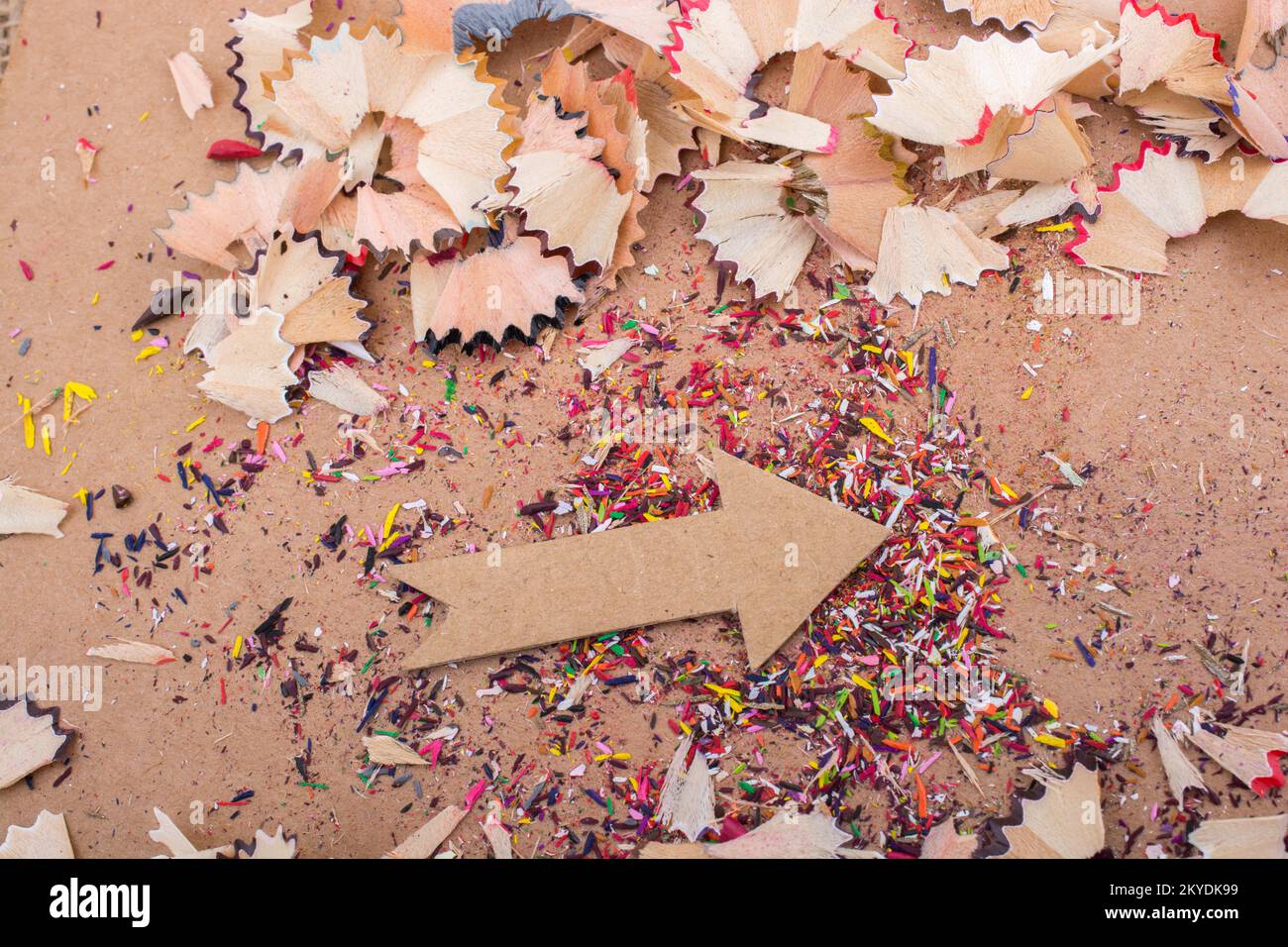 Arrow cut out of paper amid pencil shavings on canvas Stock Photo - Alamy